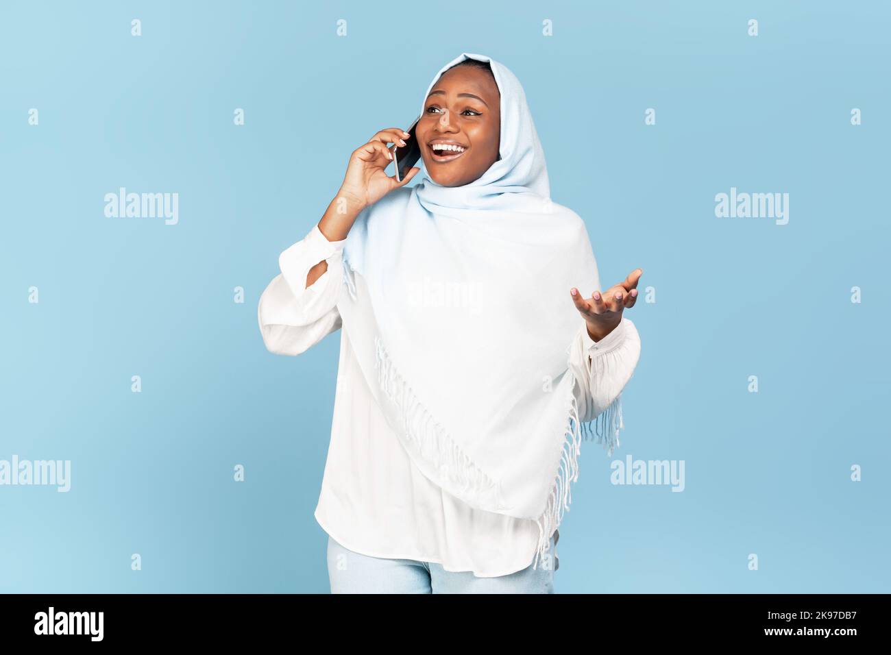 Emotional black muslim woman talking on cellphone, communicating and ...