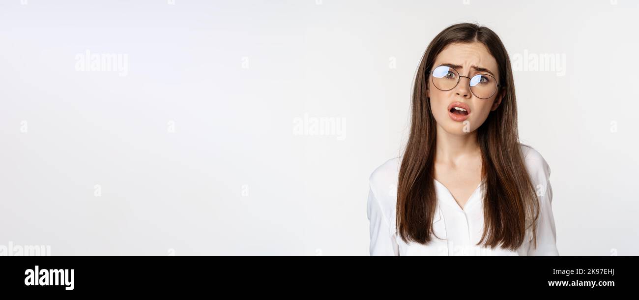 Close up of confused brunette woman in glasses, looking puzzled and ...