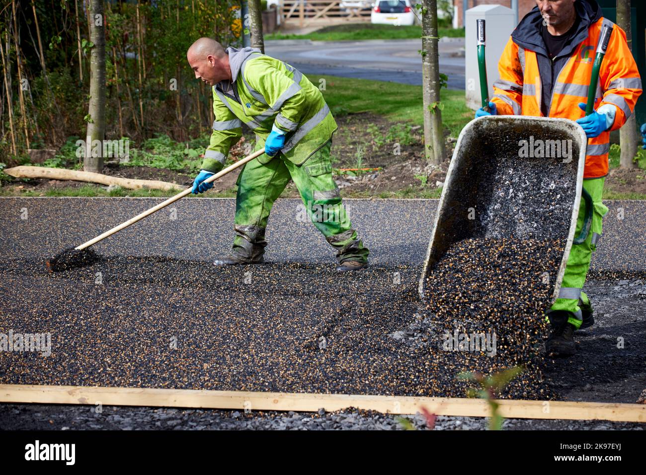 Workmen at work laying a resin drive Stock Photo - Alamy
