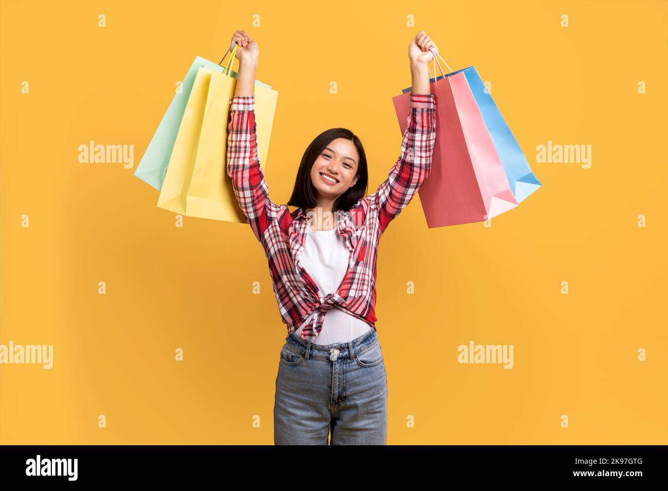 Wow, seasonal sales concept. Overjoyed asian lady holding a lot of ...