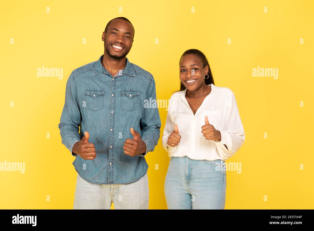 African Couple Gesturing Thumbs Up In Approval On Yellow Background ...