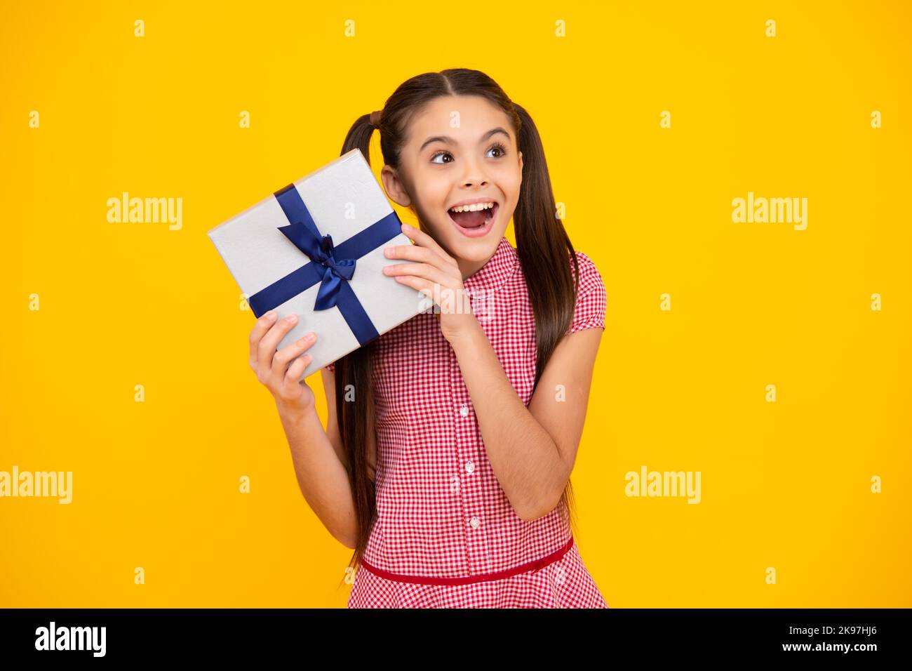 Amazed teenager. Child with gift present box on isolated background ...