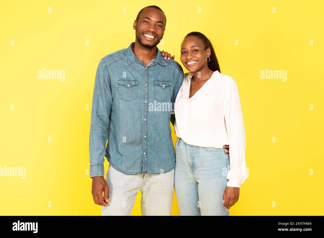 African American Spouses Embracing On Yellow Studio Background Stock ...