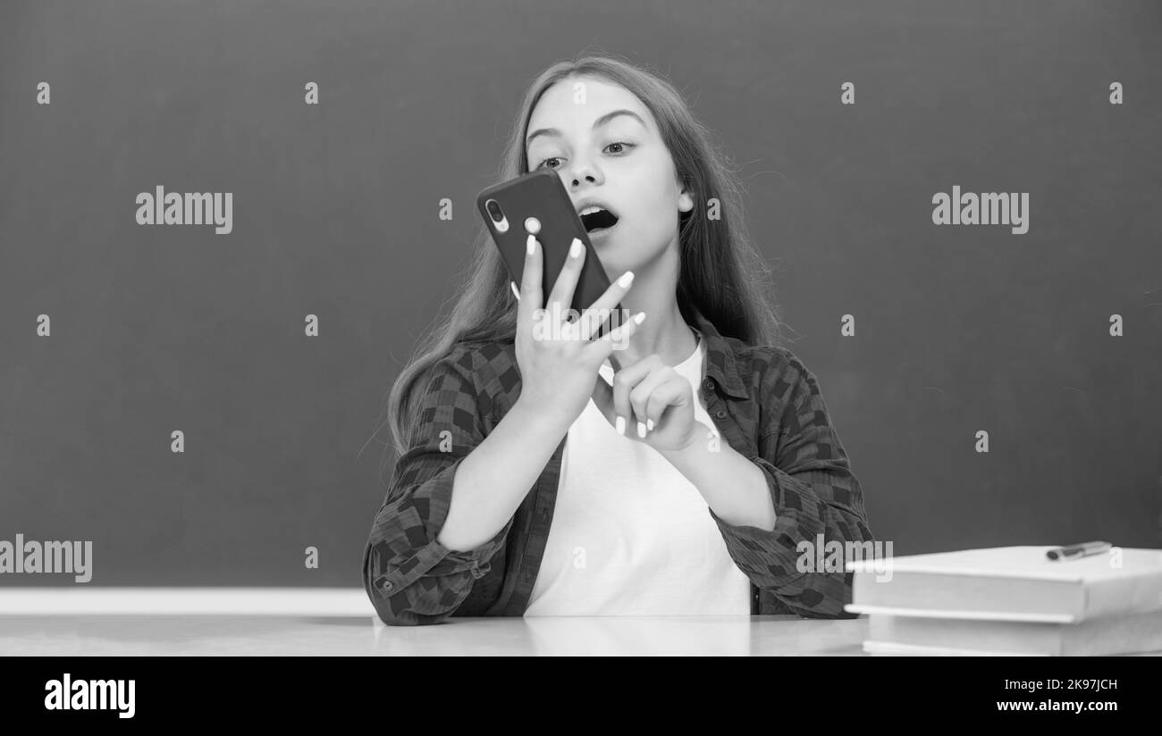 happy teen girl talking on mobile phone in high school at blackboard, voice email Stock Photo ...