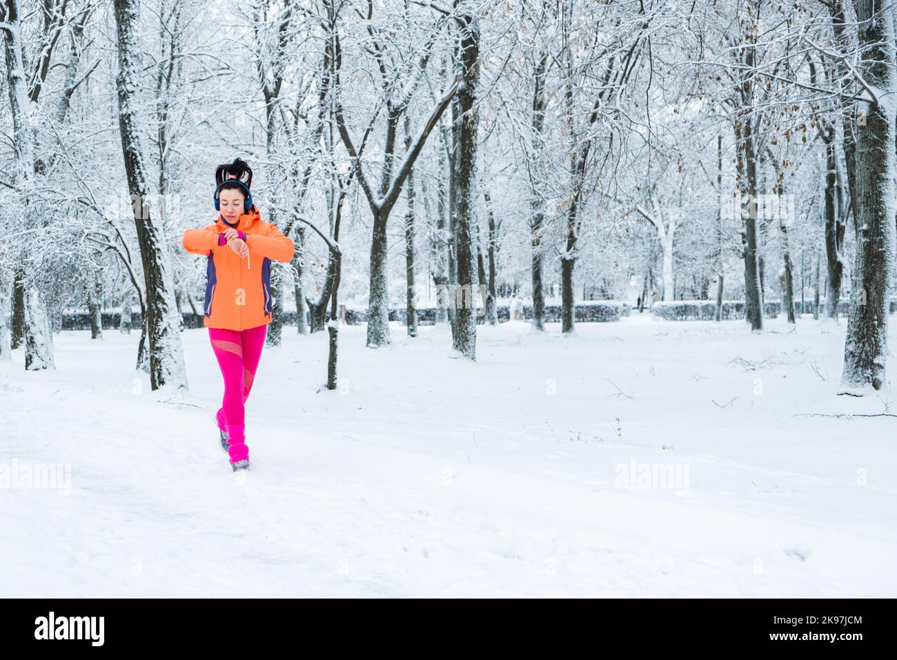 Running woman looking at smartwatch, checking heartrate and pulse ...