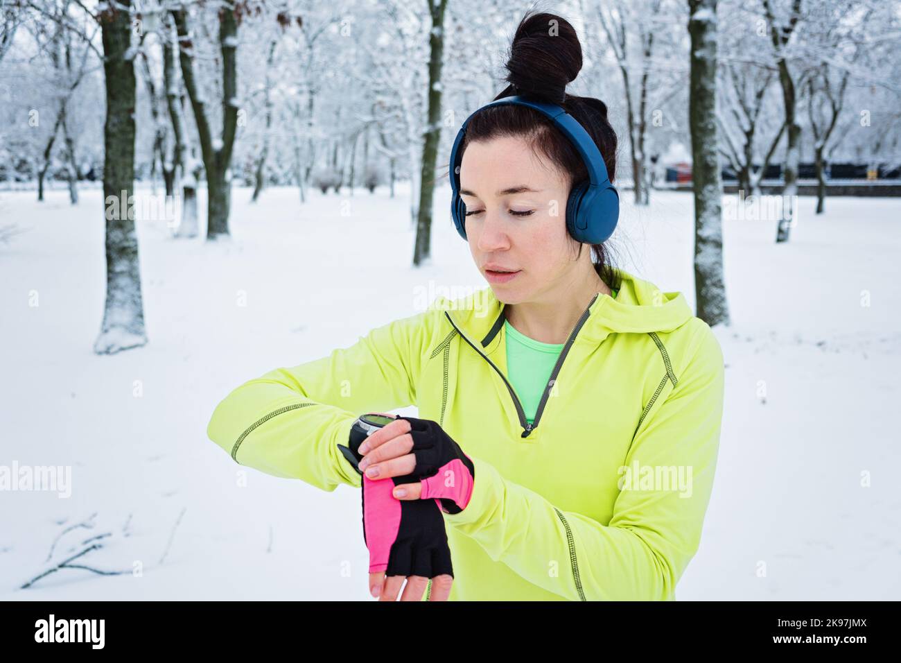 Running woman looking at smartwatch, checking heartrate and pulse ...