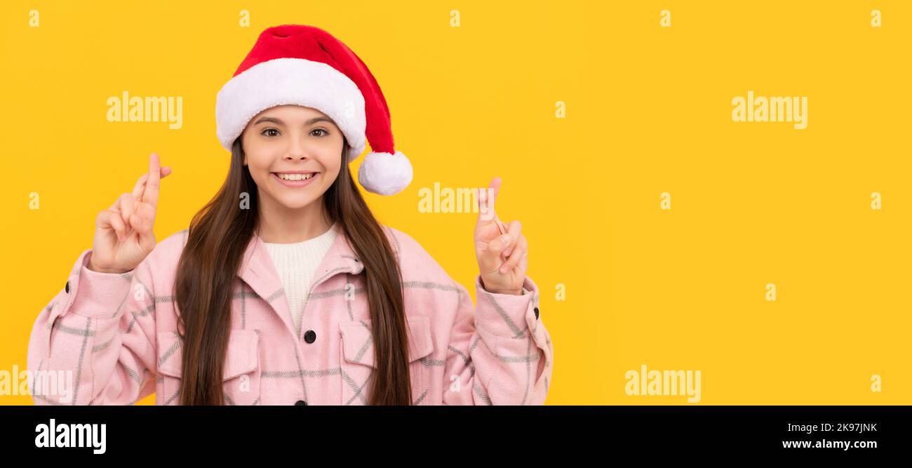merry christmas. smiling kid in santa claus hat crossed fingers for ...