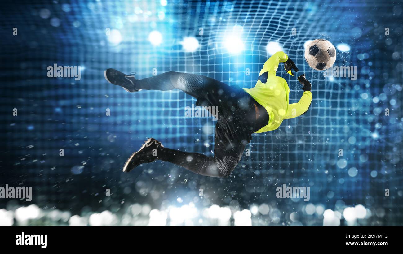 Soccer goalkeeper makes a great save and avoids a goal on a dark blue ...