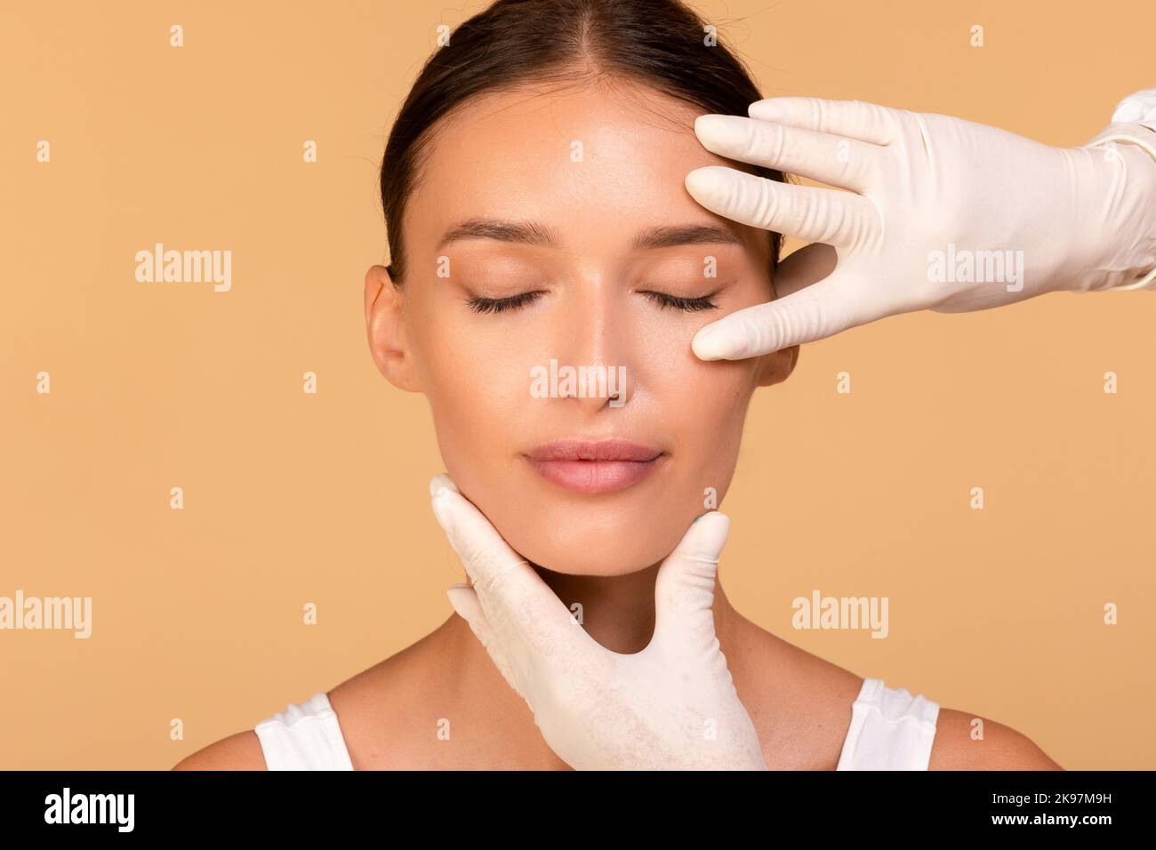 Facial treatment. Cosmetologist touching beautiful caucasian woman face ...