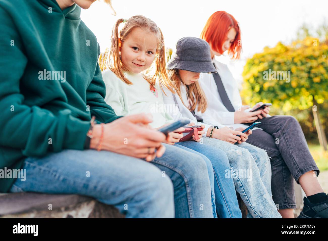 Little pretty girl portrait with sisters girls kids sitting in a row ...