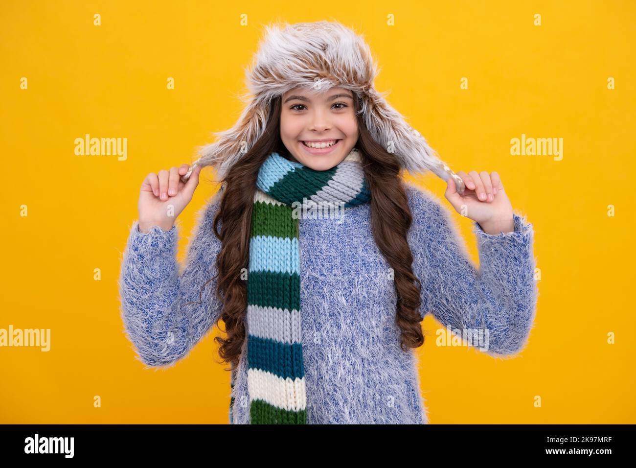 Beautiful teen girl in a winter hat and a warm sweater. A child on a ...
