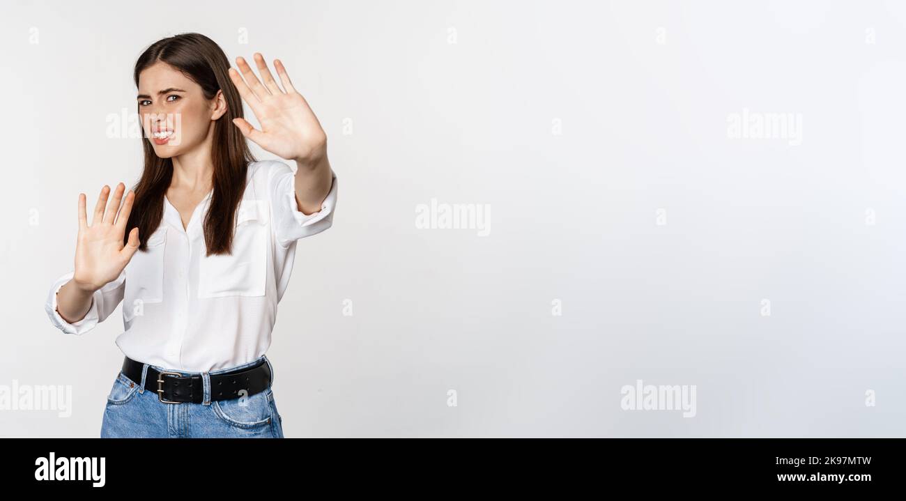 Displeased woman showing stop, rejection gesture, waving hands to ...