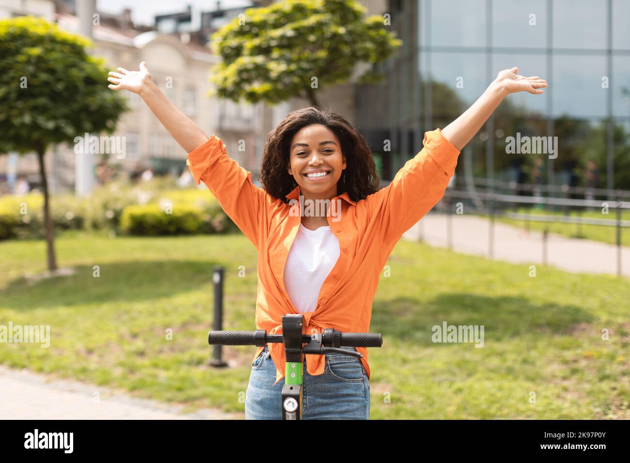 Cheerful millennial african american lady in casual raising hands up on ...