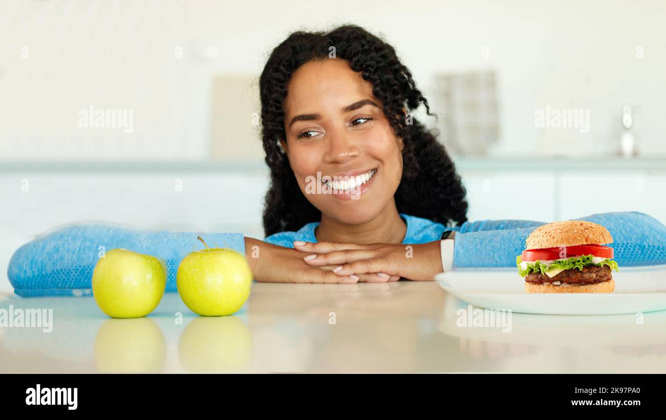 Choice between healthy and unhealthy food. African american woman ...