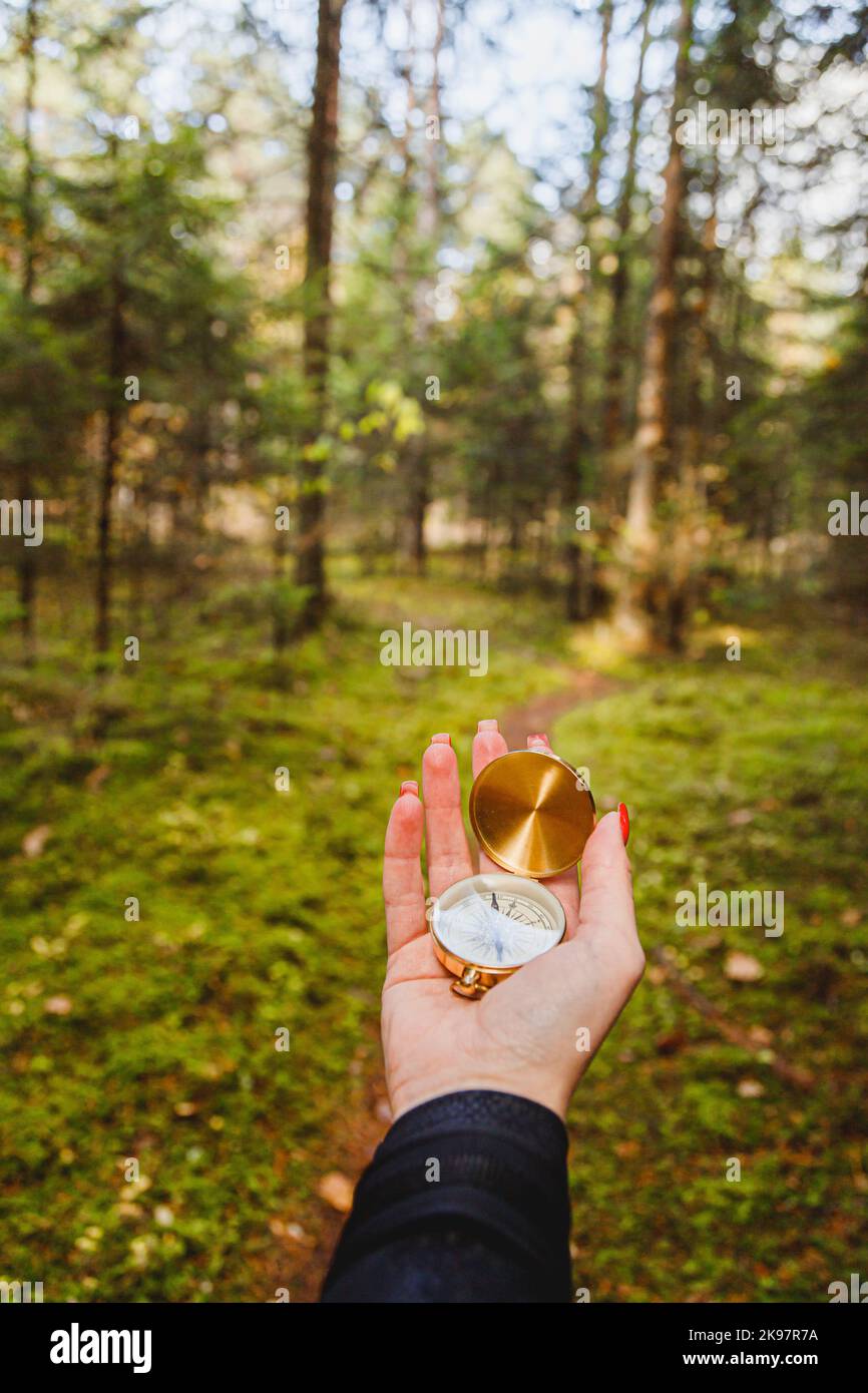 Hand with compass in forest terrain. POV Travel concept Stock Photo - Alamy