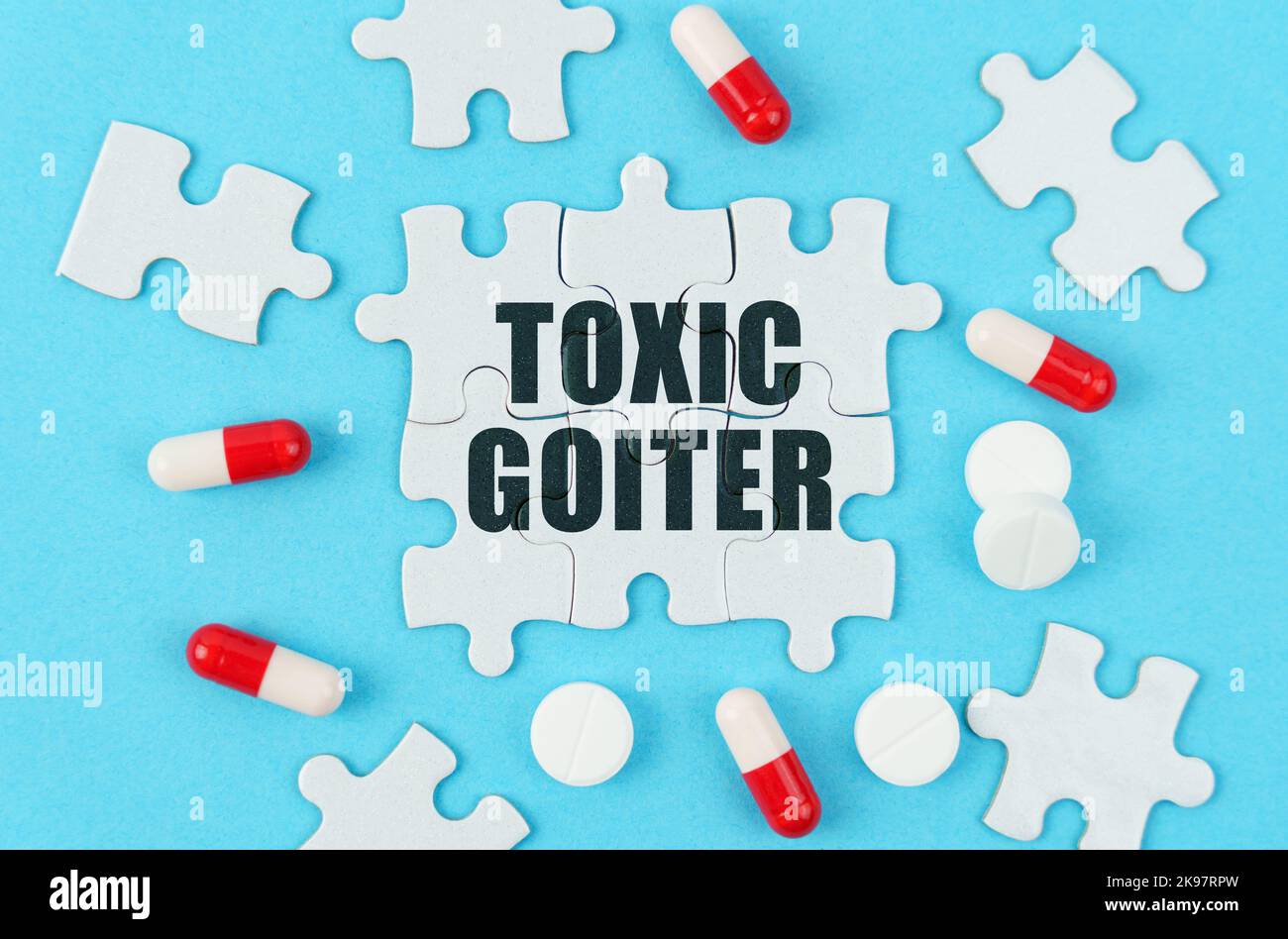 Medical concept. On a blue background, pills, capsules and puzzles with ...