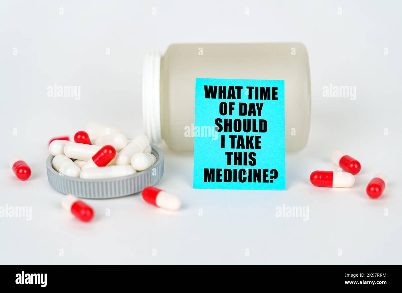 Medical concept. On a gray background, a jar, capsules and a sign with ...