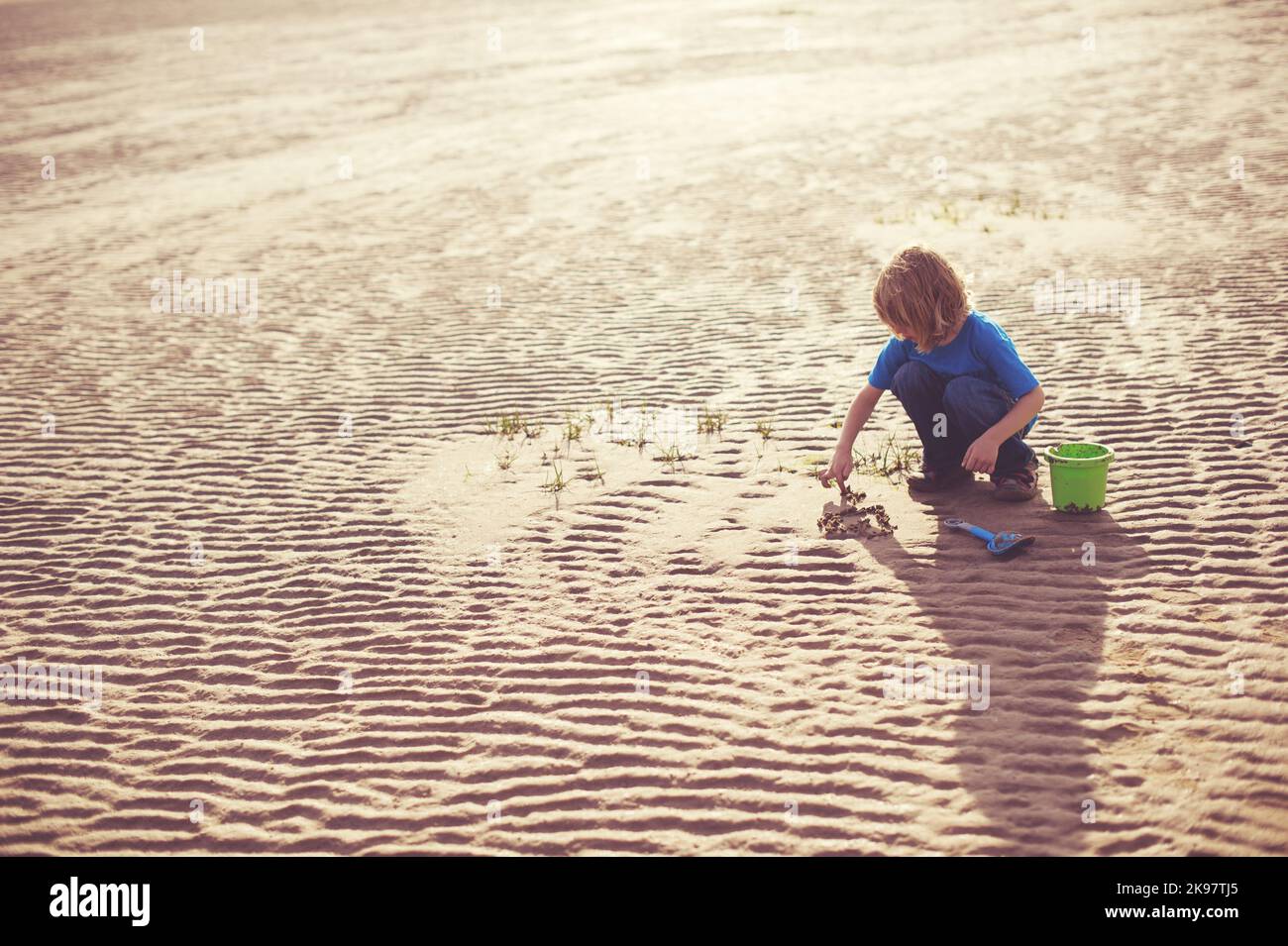 Child On The Beach With Bucket And Spade Reflective Stock Photo - Alamy