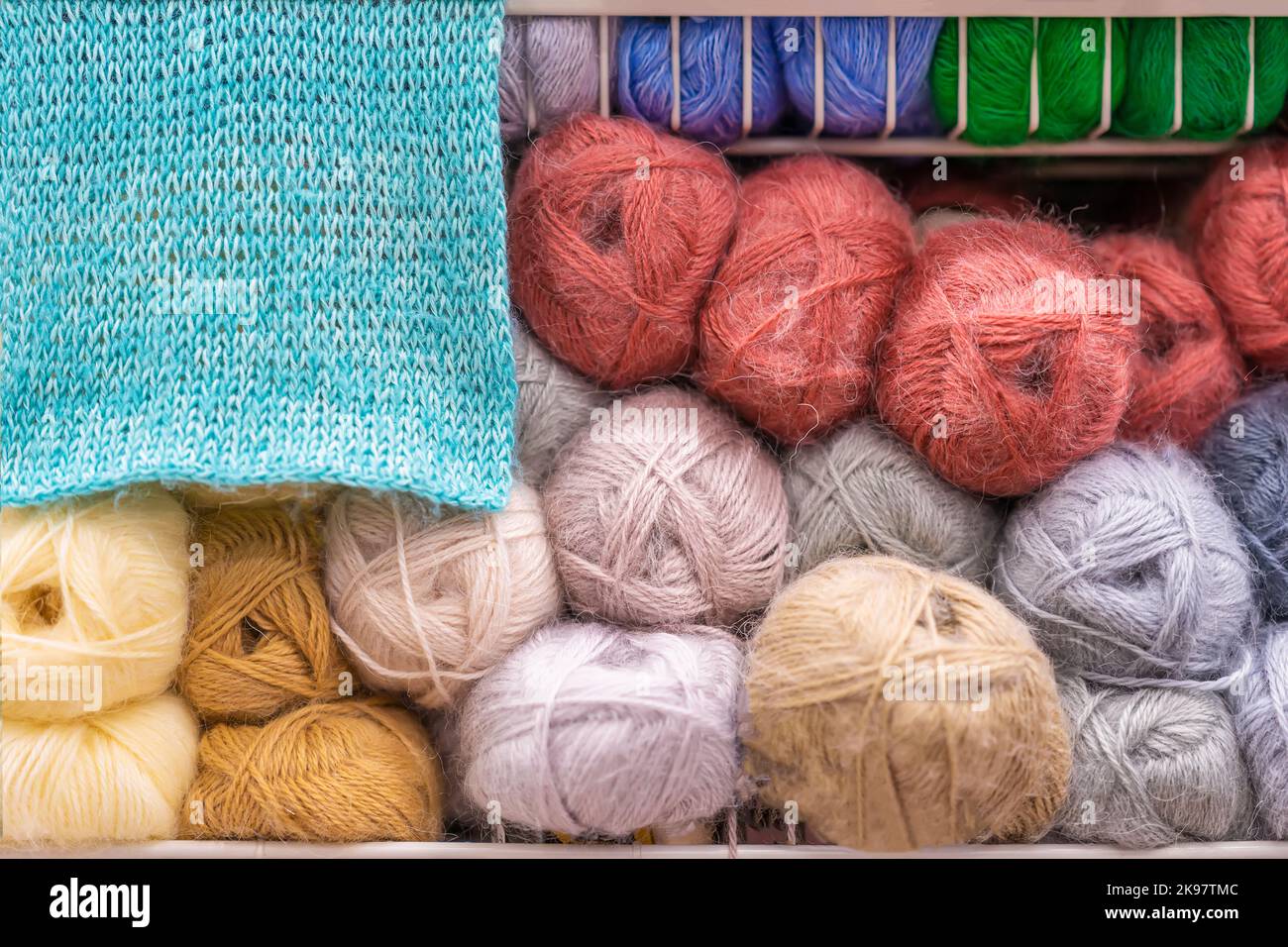 Fluffy skeins of mohair, yarn for knitting and knitted piece, shelf in ...