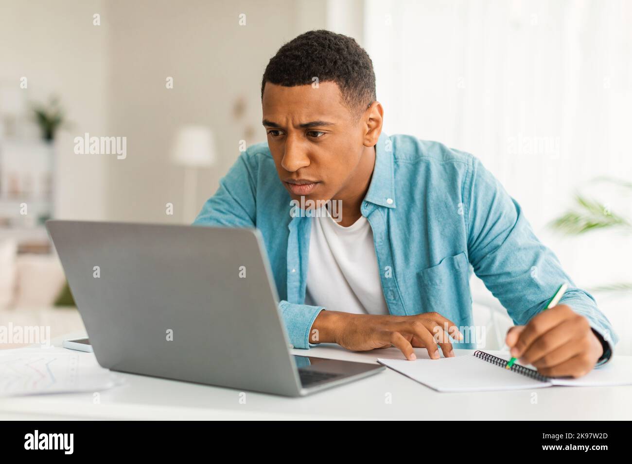 Serious concentrated bored young african american male in jeans looking ...