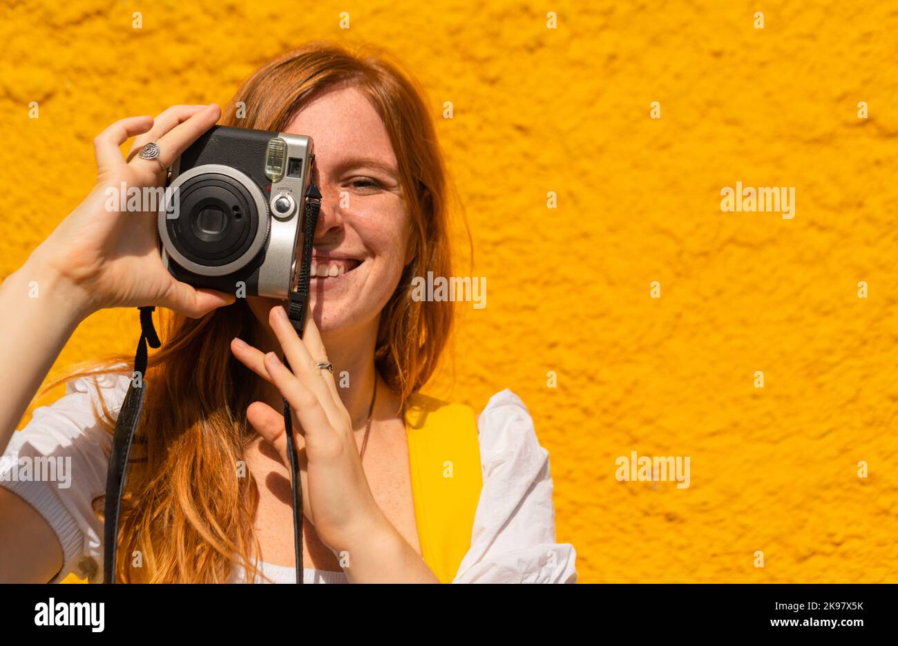 Close-up image of a traveler making a photo of something against yellow ...