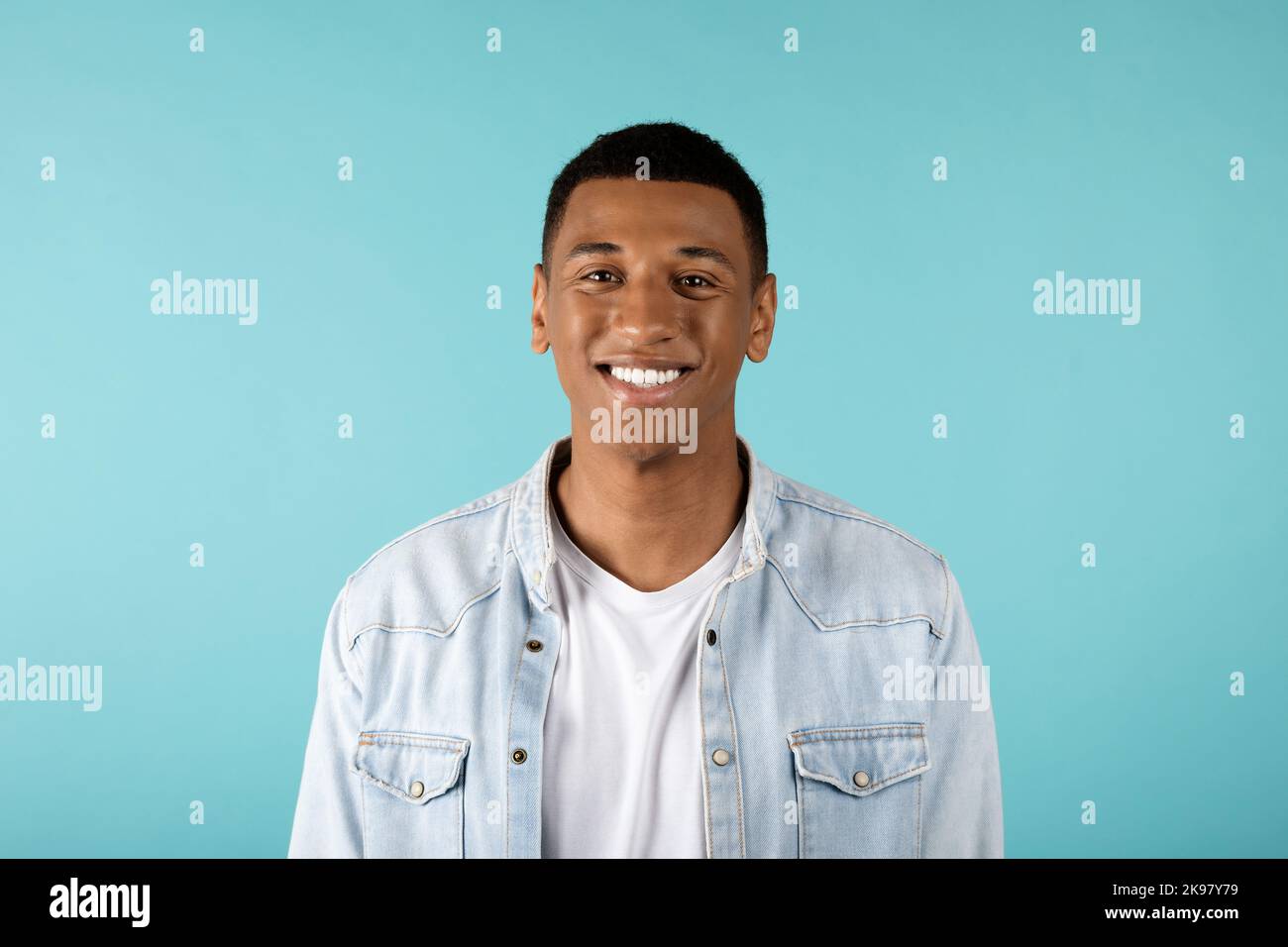 Portrait of happy attractive millennial african american guy in jeans look at camera Stock Photo ...