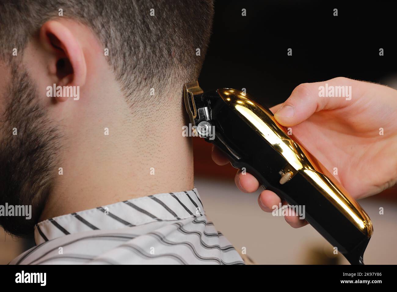 Hairdresser, barber cutting the hair from the back of the client's head ...