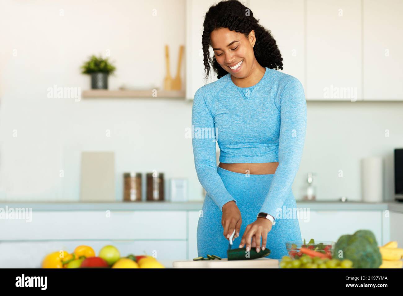 Sporty african american lady cooking healthy vegetarian food, preparing ...