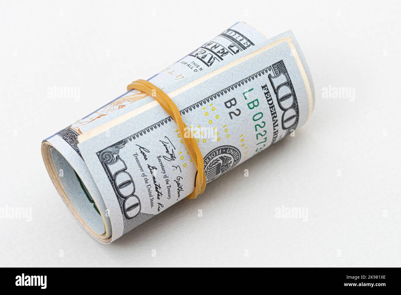 US dollar rolled up with a rubber band isolated on white. the most ...