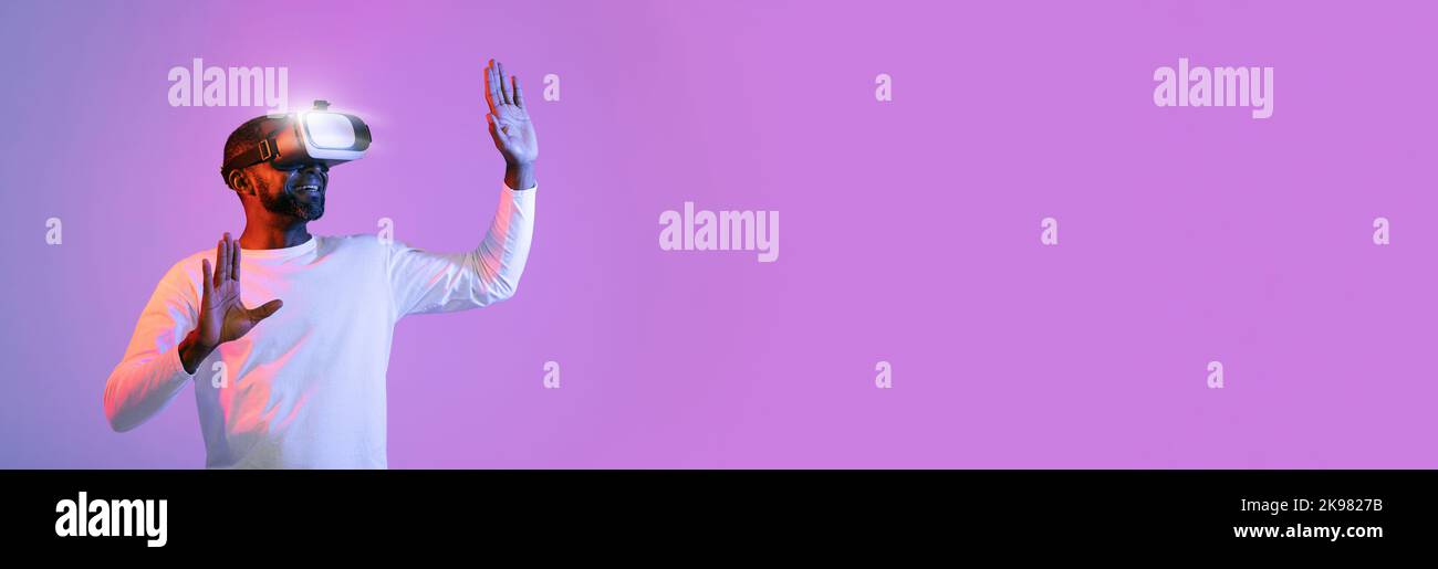 Excited black man using VR glasses on neon background Stock Photo - Alamy