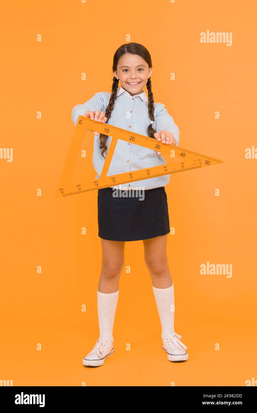 A triangle has three sides and three angles. Adorable happy schoolchild ...