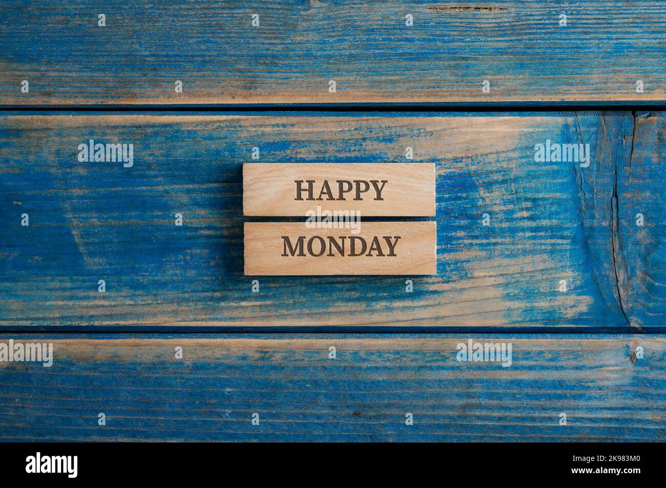 Happy monday sign written on two stacked wooden pegs placed over ...