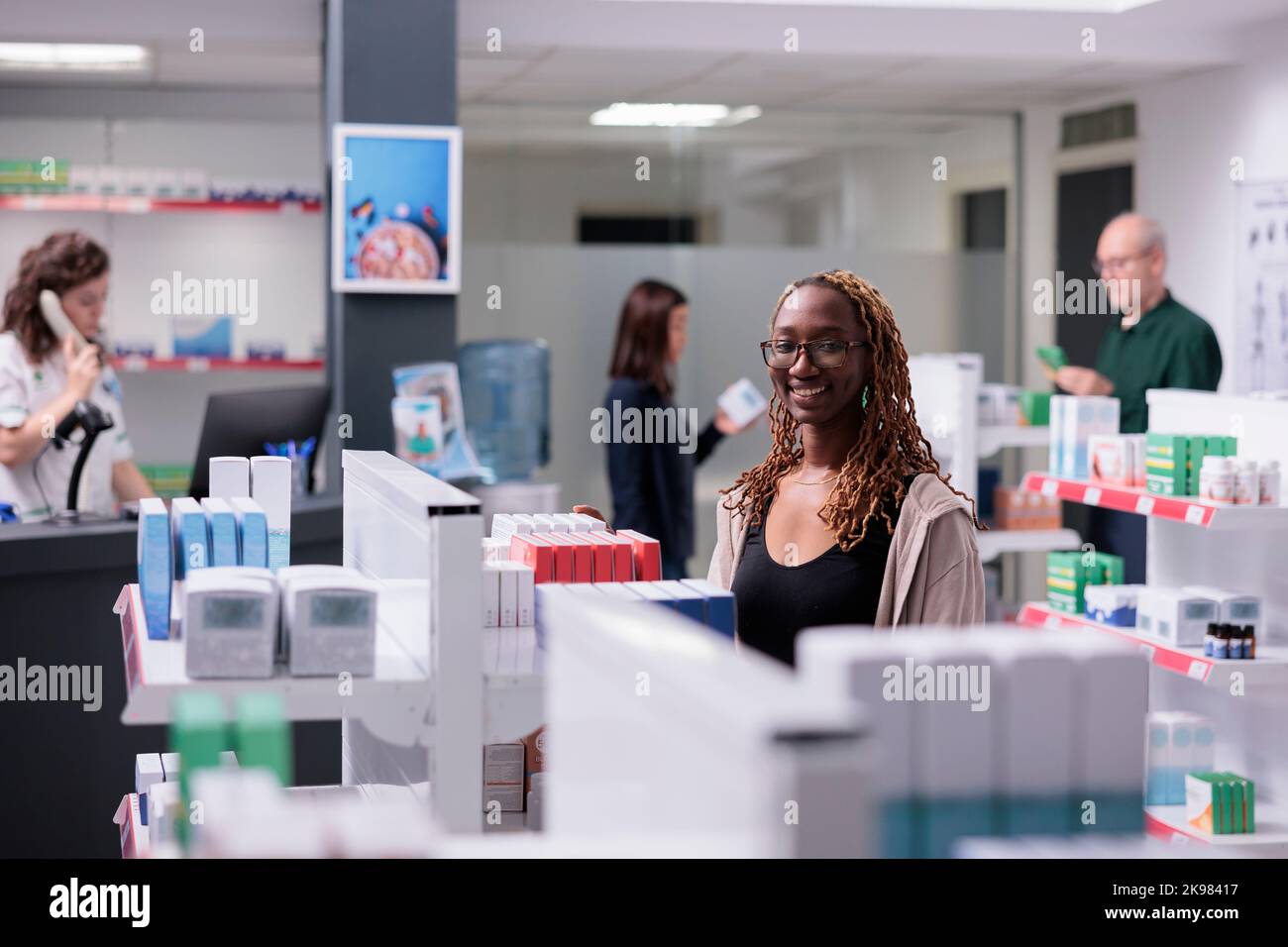 Cheerful client looking at shelves full of drugs, shopping for ...
