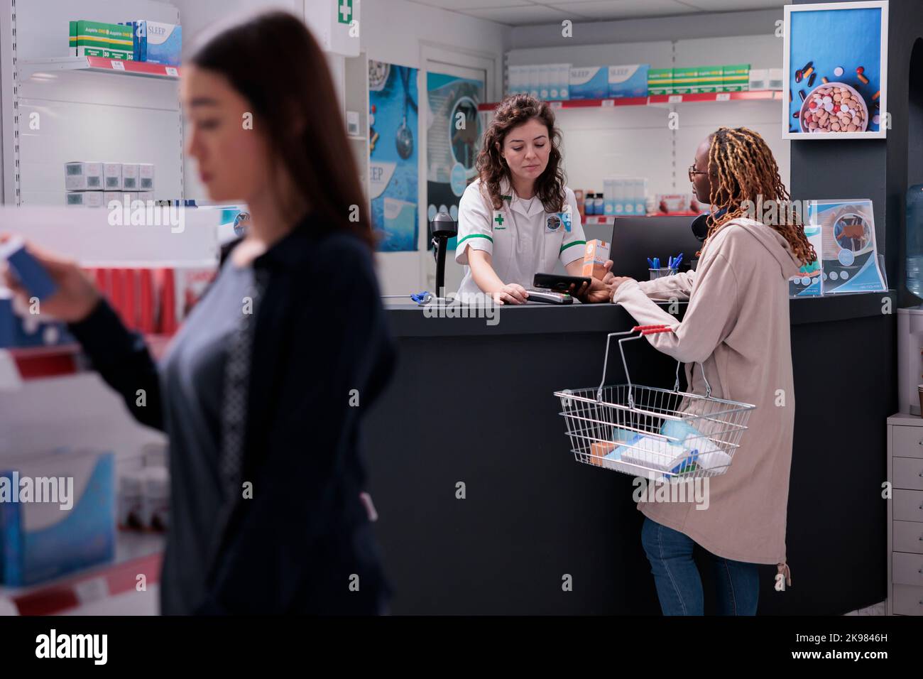 Woman client using terminal for contactless payment with phone during ...