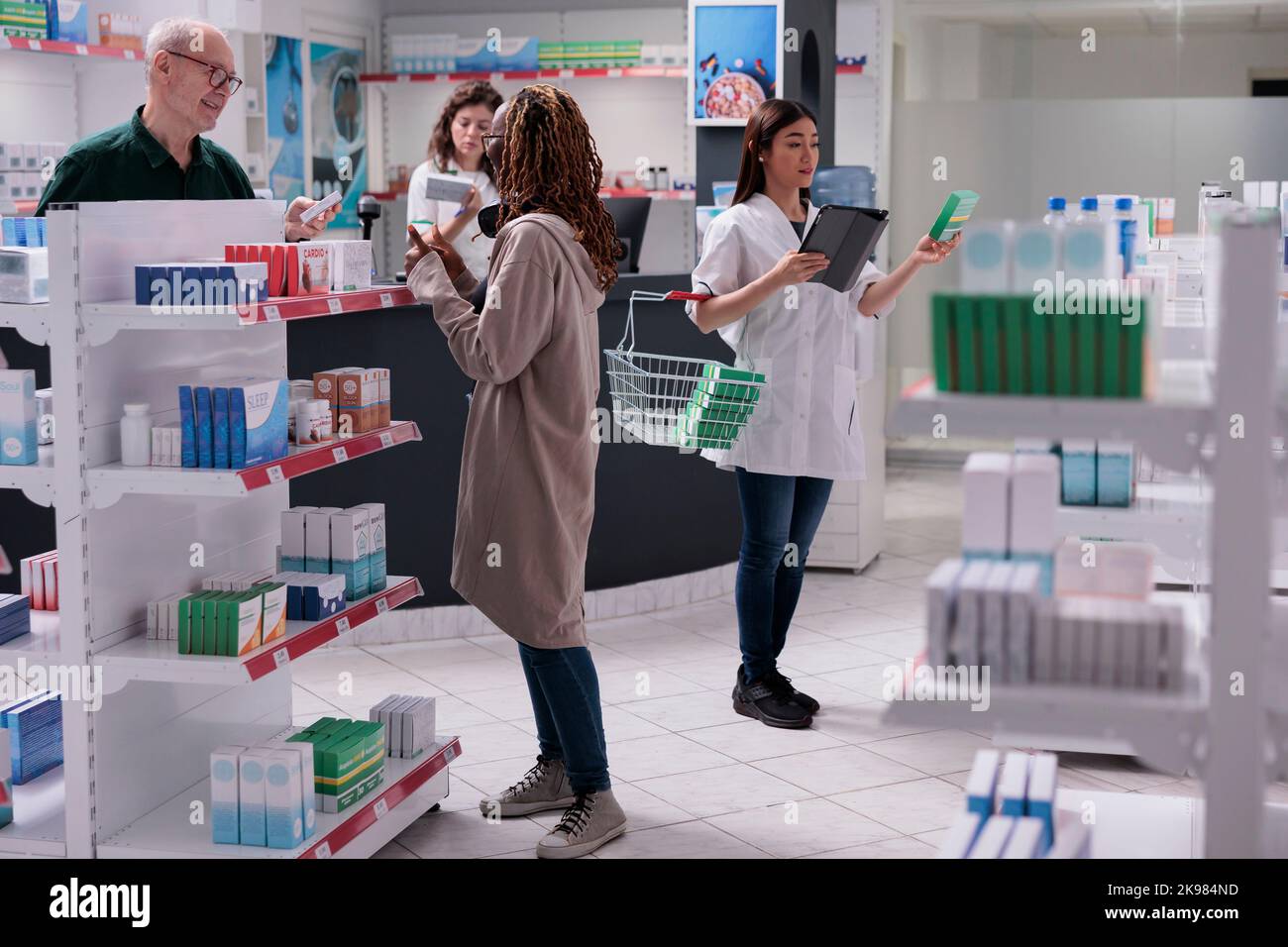 Helpful client talking with old customer in pharmacy discussing about ...