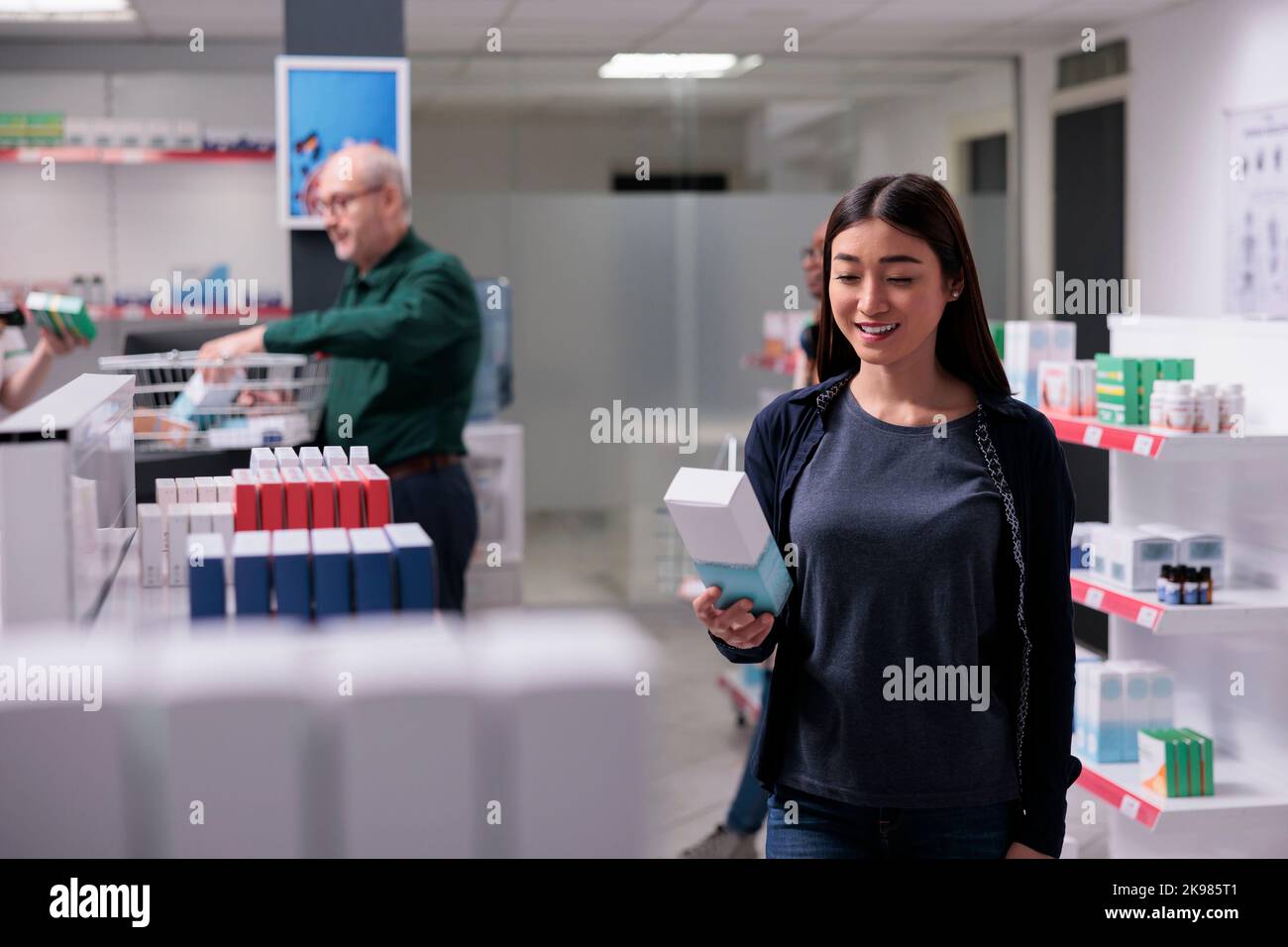 Asian customer holding pills package reading presription before buy it ...