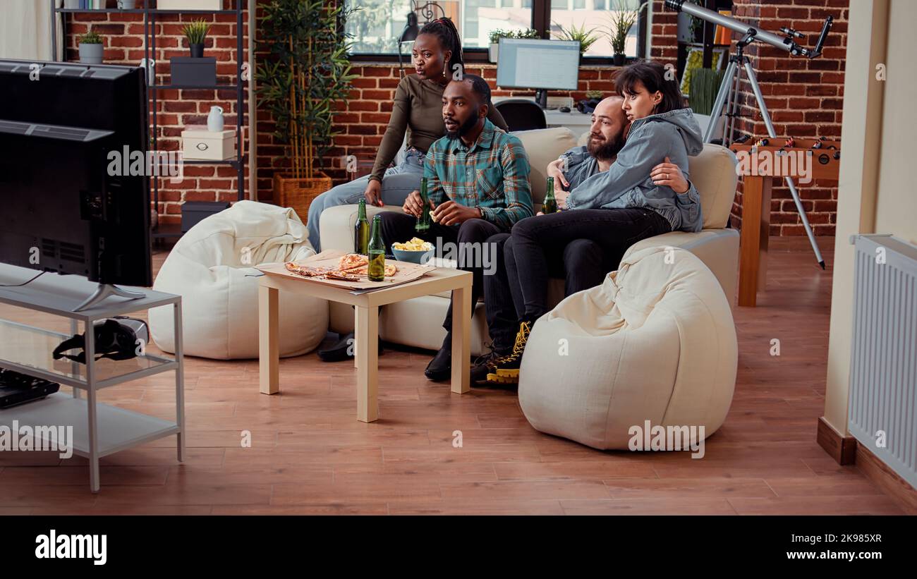 Scared group of friends watching horror film on tv channel, being ...