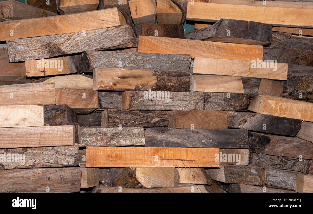 Stacked raw wood logs and planks Stock Photo - Alamy