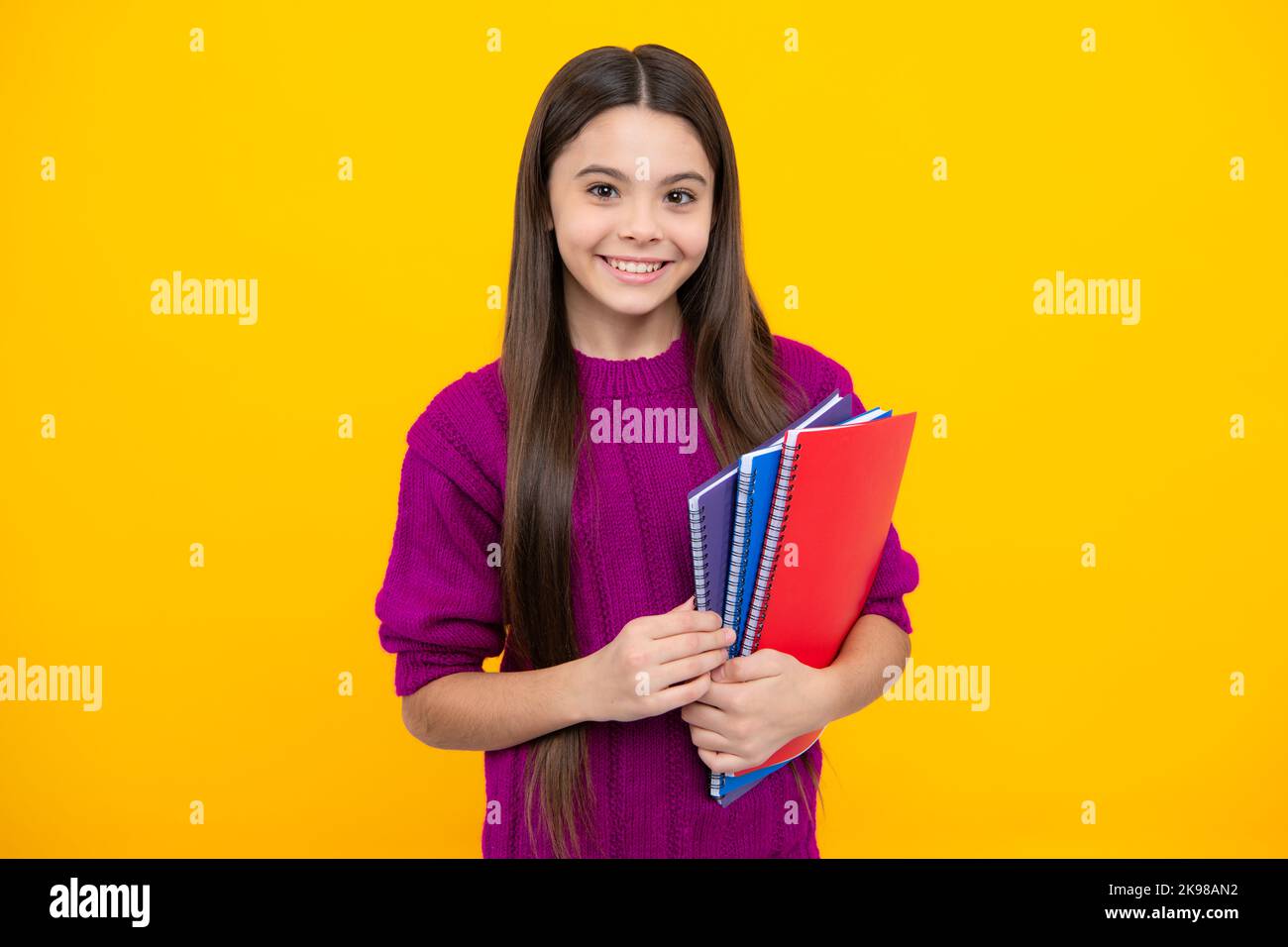 Teen girl pupil hold books, notebooks, isolated on yellow background ...