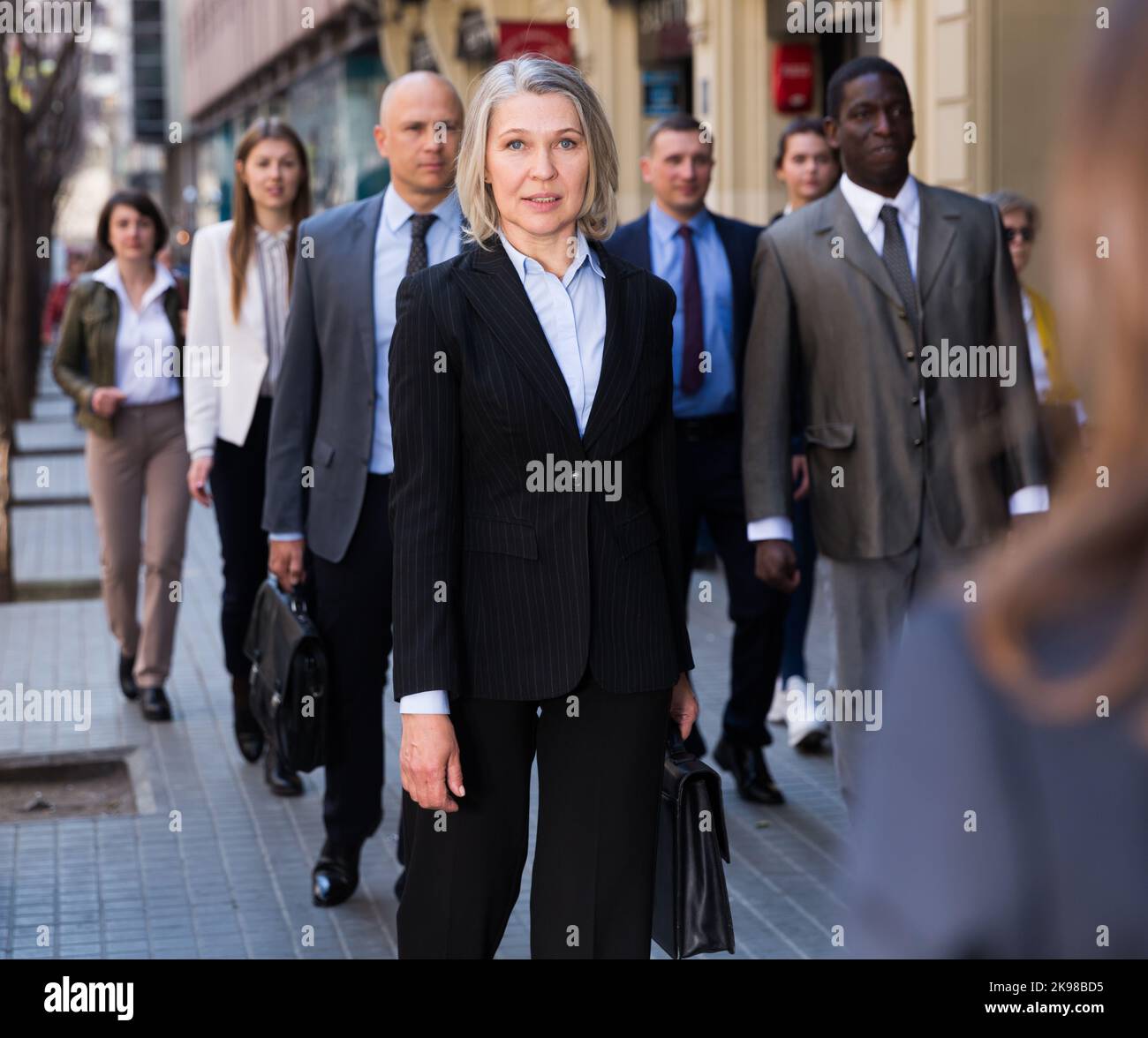 People in formal wear walking down street Stock Photo - Alamy