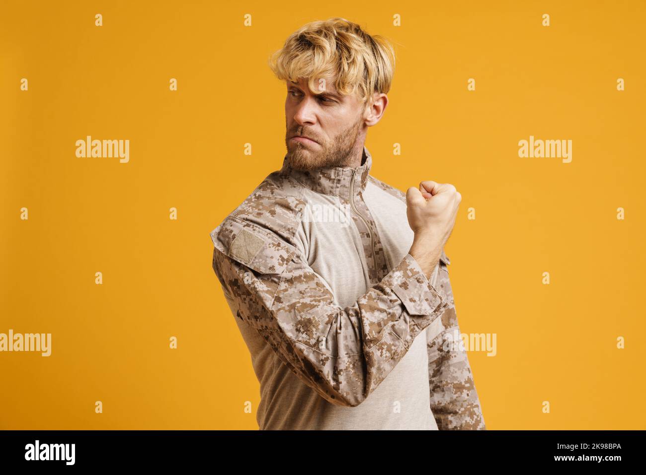 European military man wearing uniform showing his bicep at camera ...