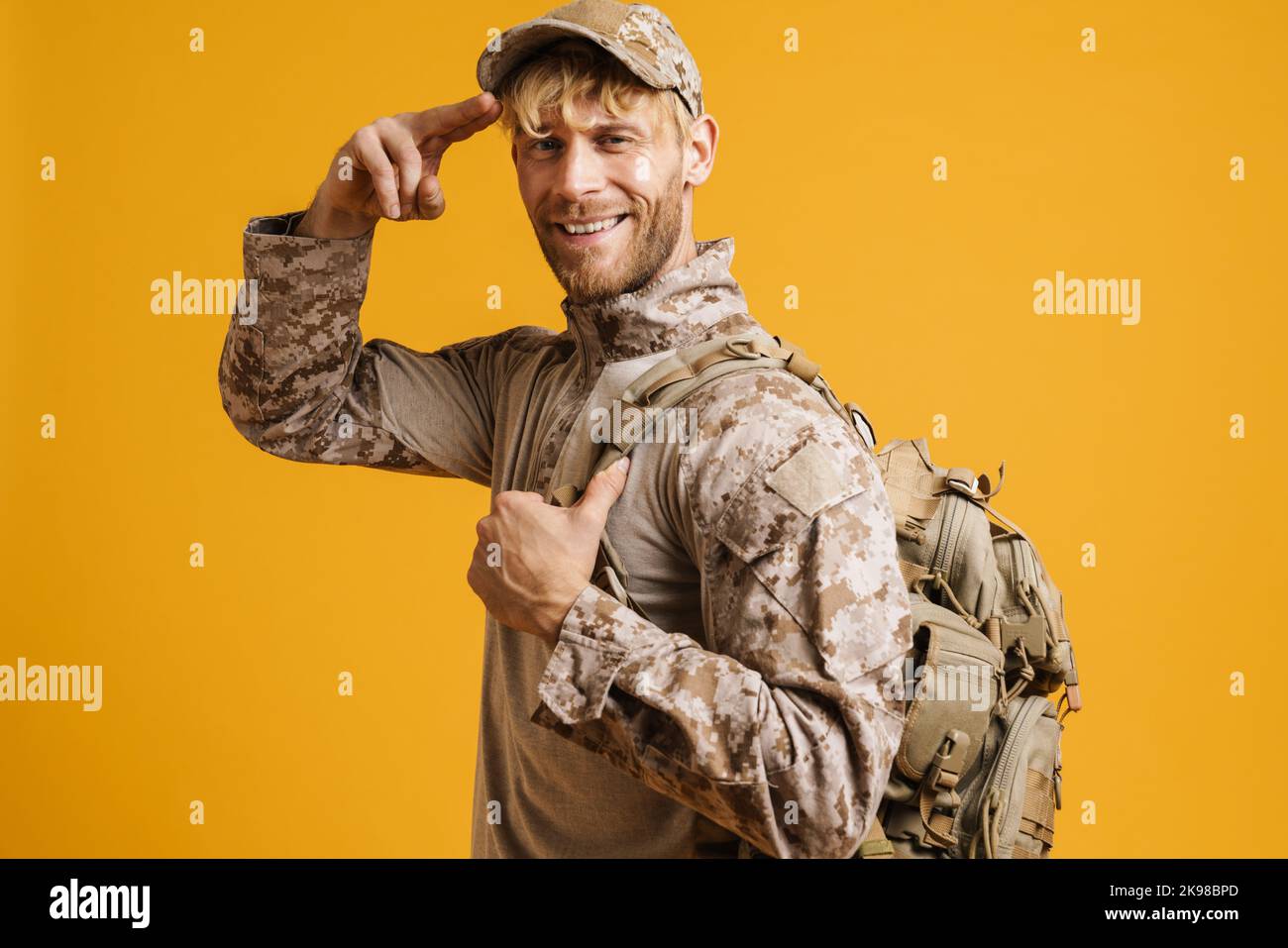 White military man wearing uniform smiling and saluting isolated over ...