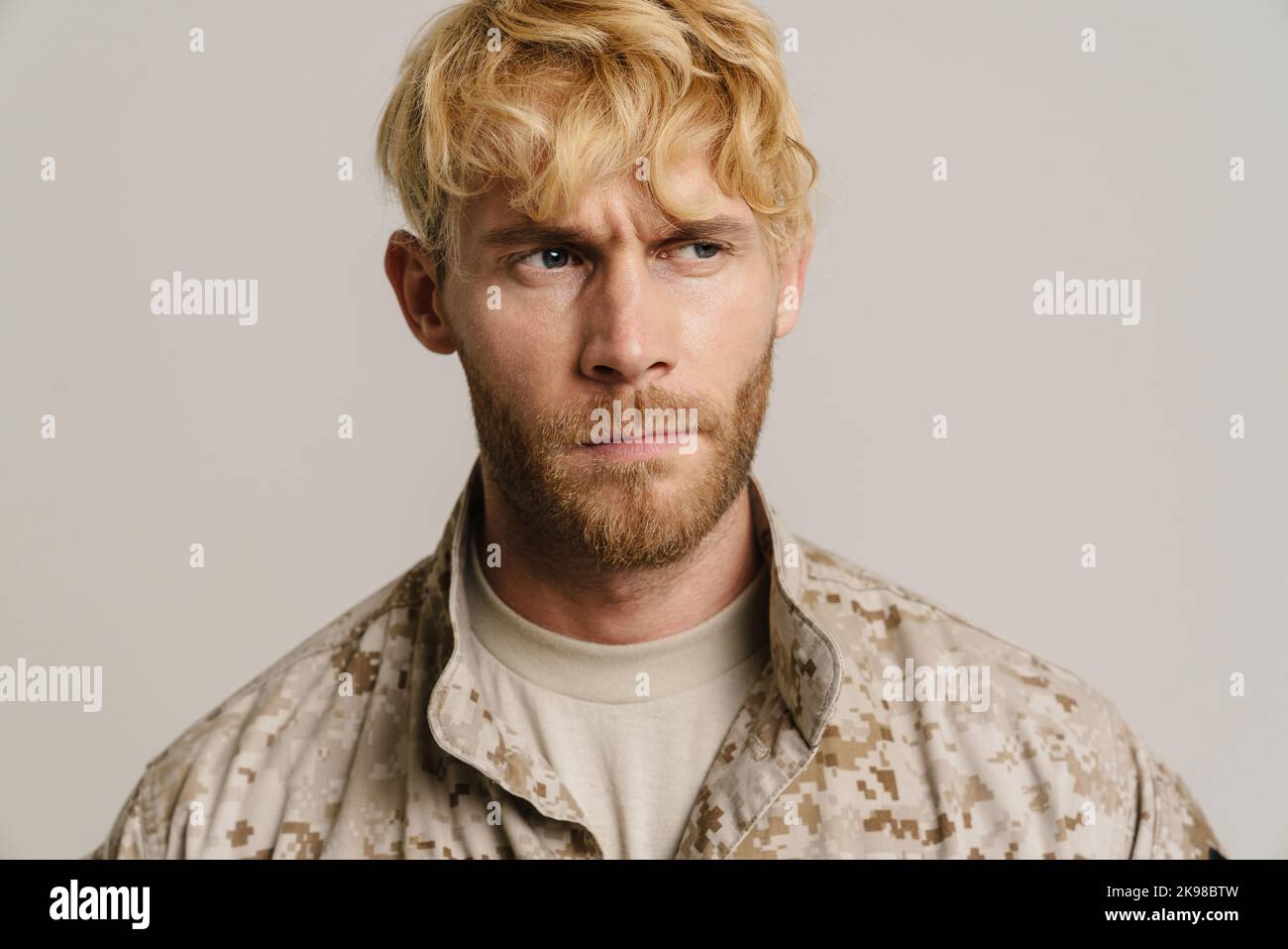 European military man wearing uniform posing and looking aside isolated ...