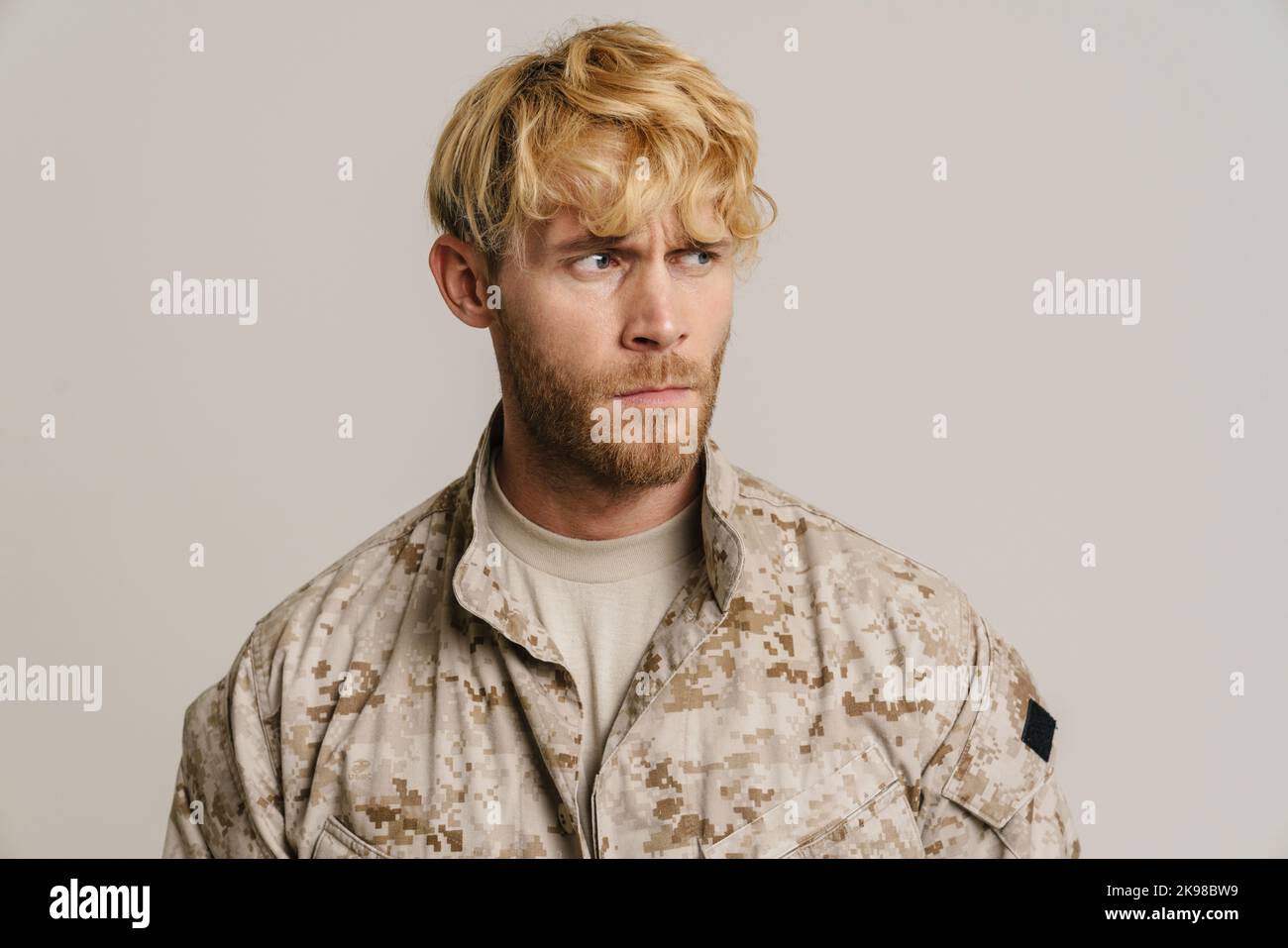 White military man wearing uniform frowning and looking aside isolated ...