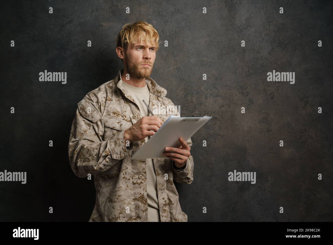 White military man wearing uniform posing with clipboard isolated over ...
