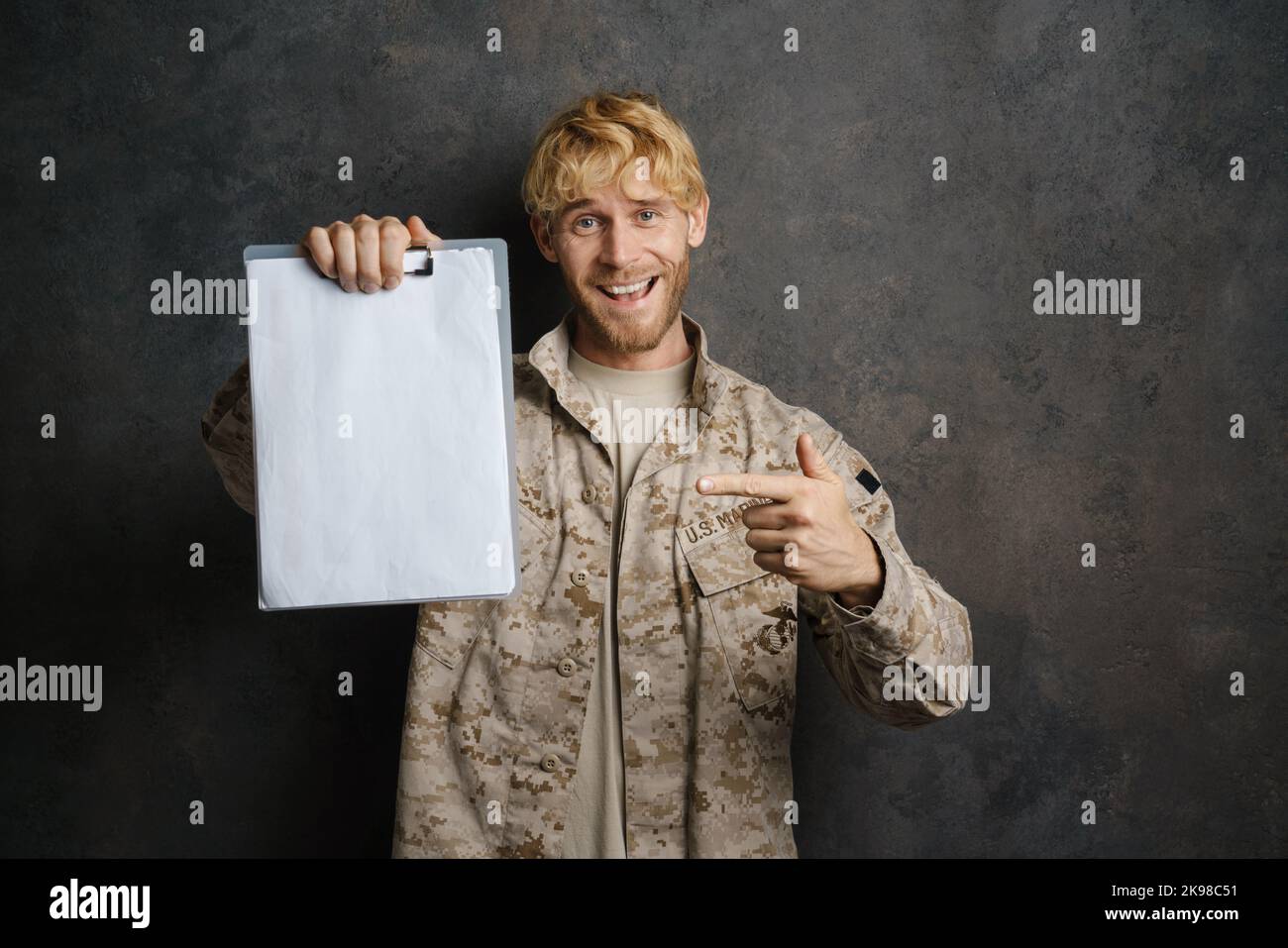 White military man wearing uniform pointing finger at clipboard ...