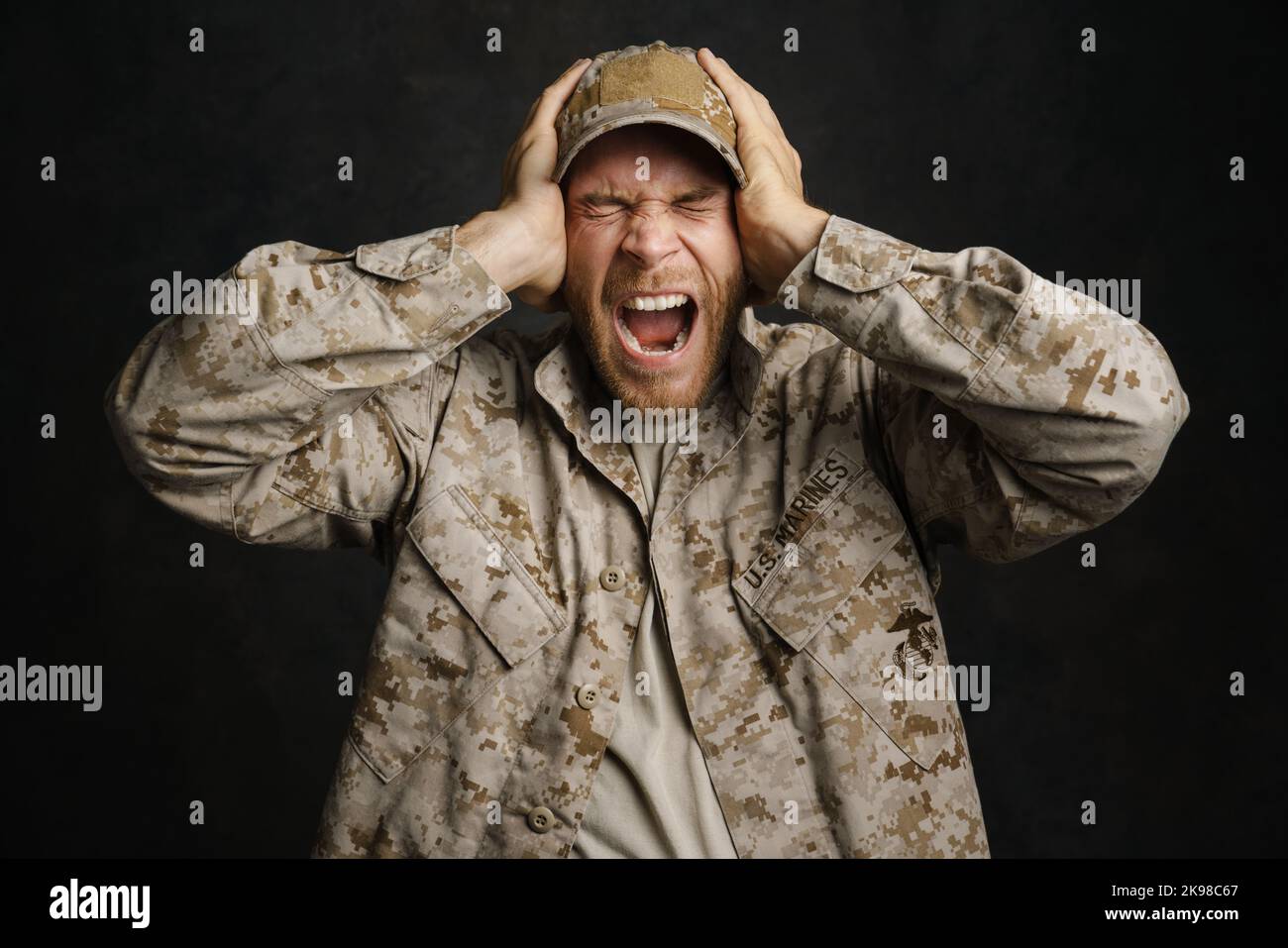 White military man wearing uniform screaming while holding his head ...
