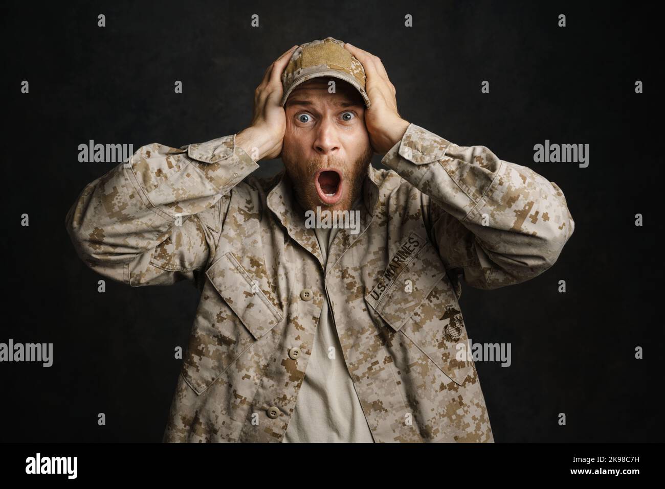 White military man wearing uniform screaming while holding his head ...