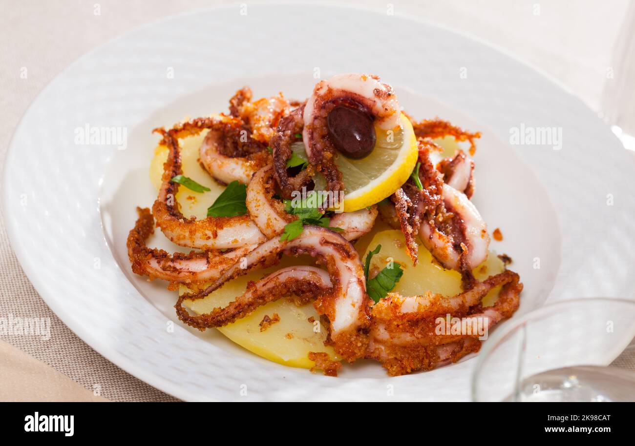 Roasted squid legs with lemon Stock Photo - Alamy