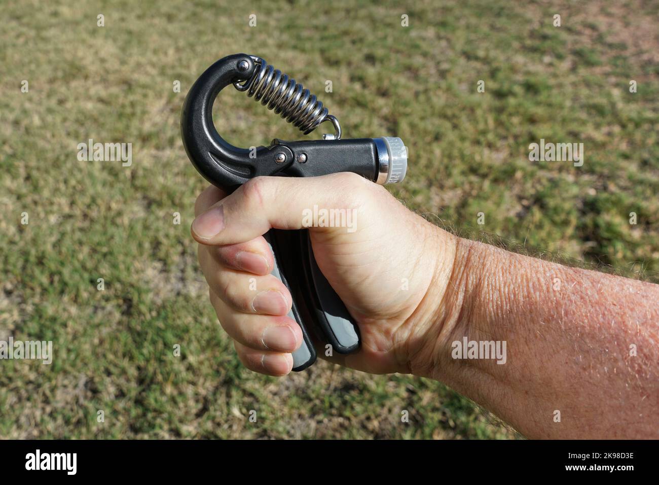 Close up of a man's hand using an adjustable hand strengthener to ...
